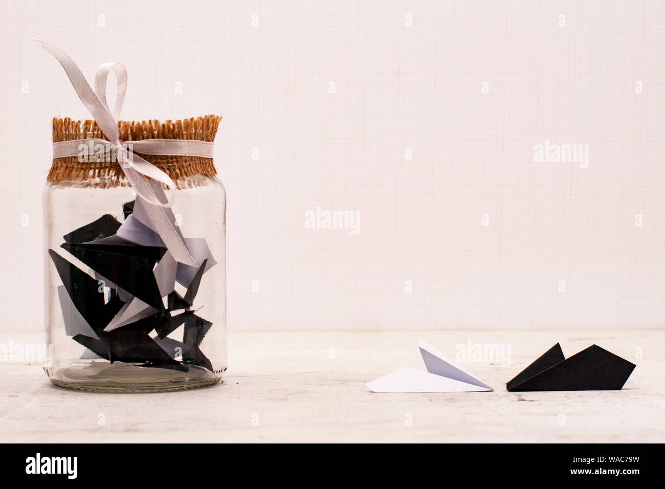 A glass jar with colored Airplanes of craft paper. Black and white ...