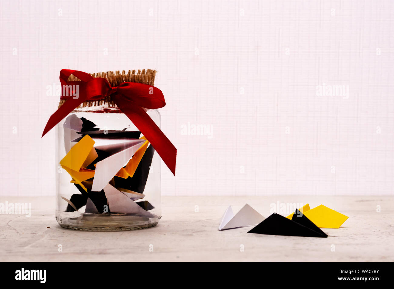 A glass jar with colored Airplanes of craft paper. Black and white ...