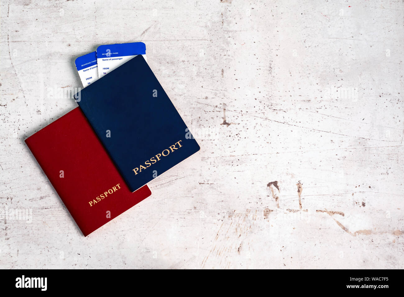 Two travelers passports red and blue with boarding passes for the plane ...