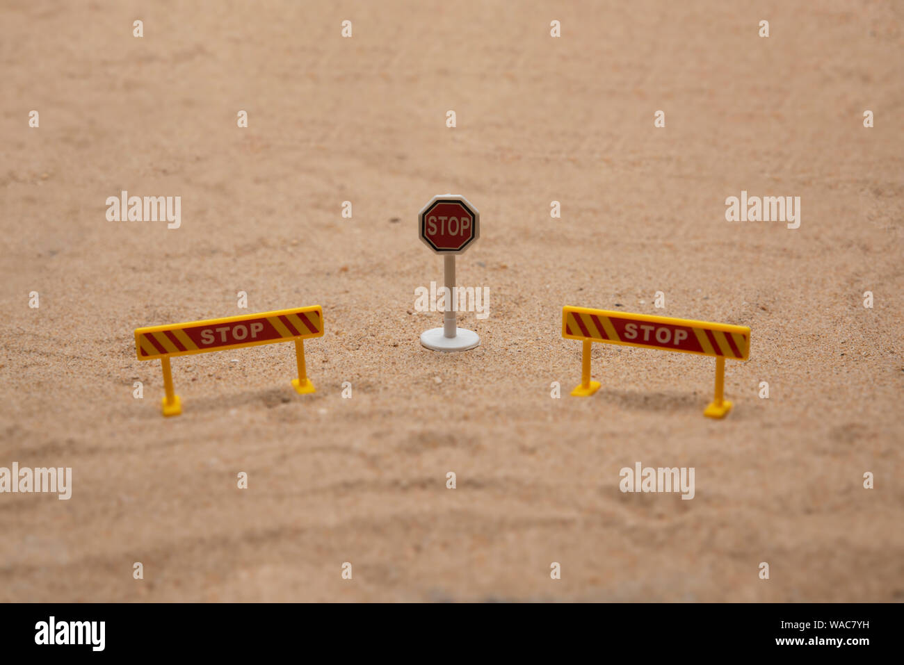 Isolated warning yellow stop signs on sand Stock Photo - Alamy