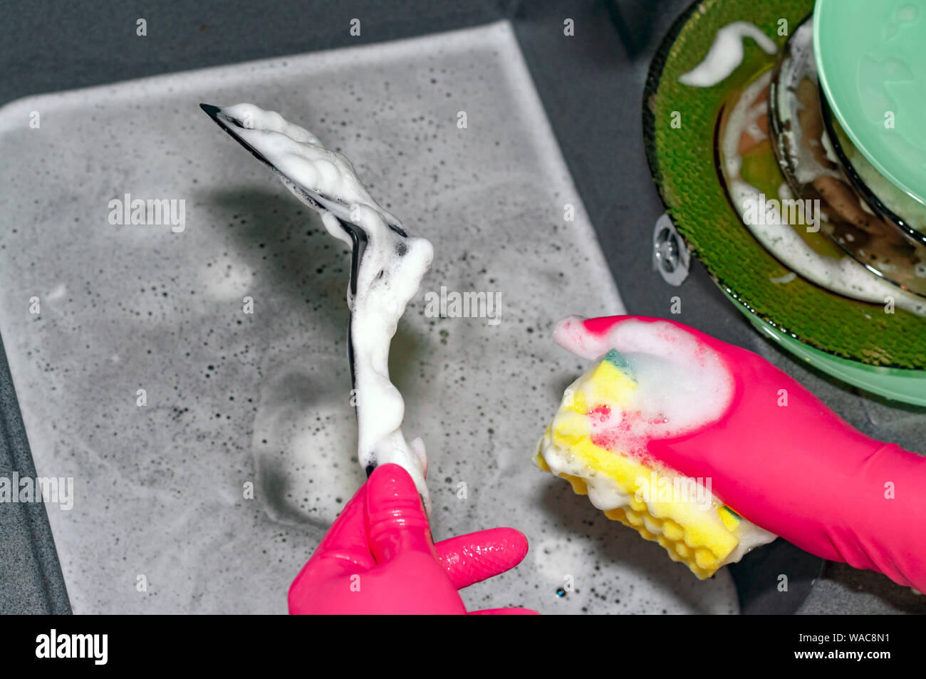 The process of washing plates in the sink, hands and plates closeup ...