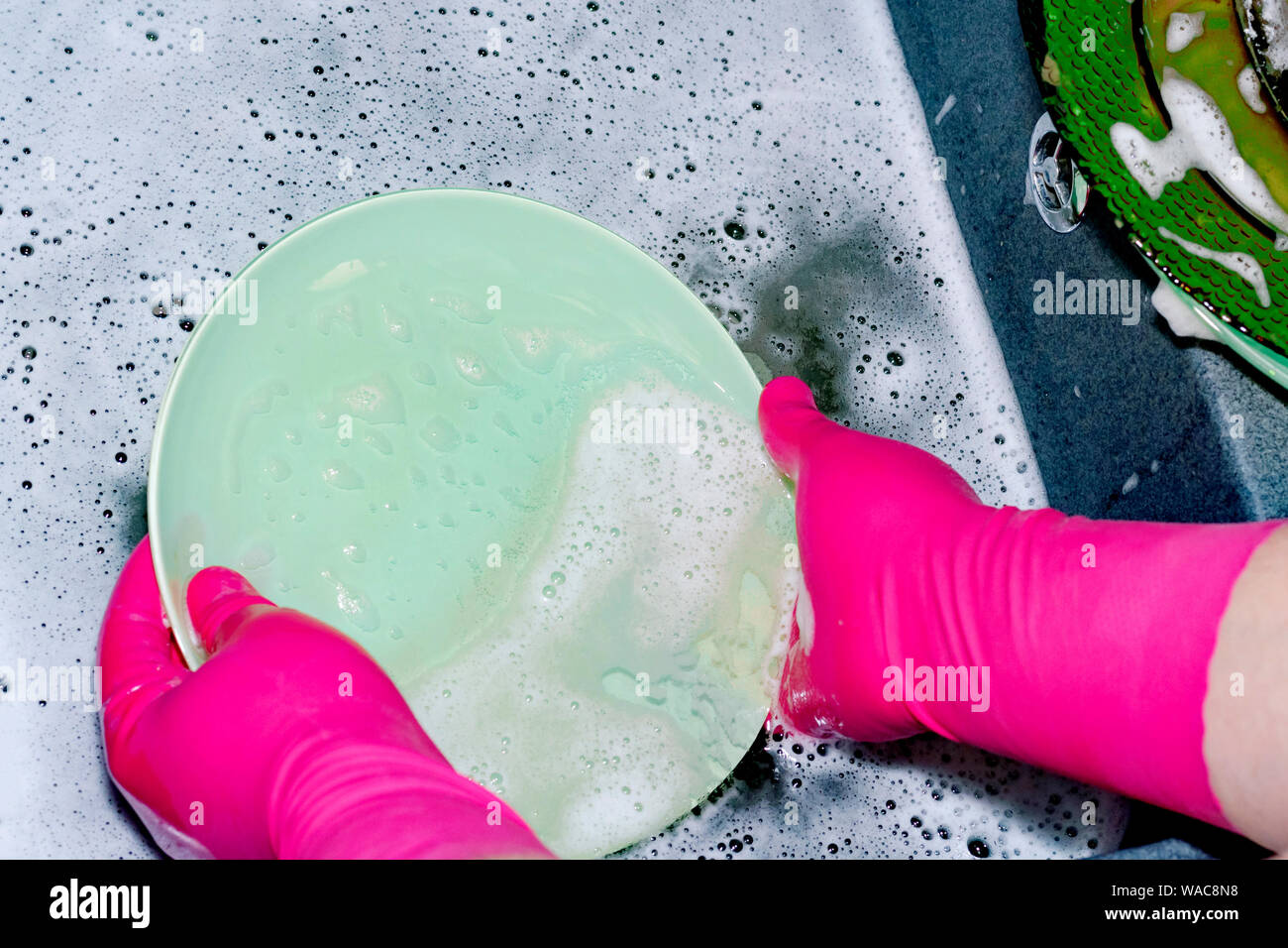 The process of washing plates in the sink, hands and plates closeup ...