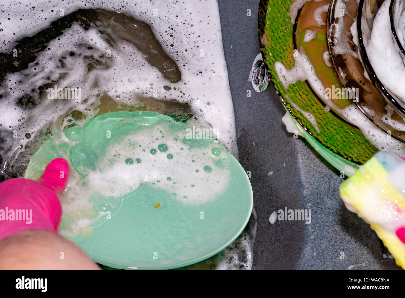 The process of washing plates in the sink, hands and plates closeup ...