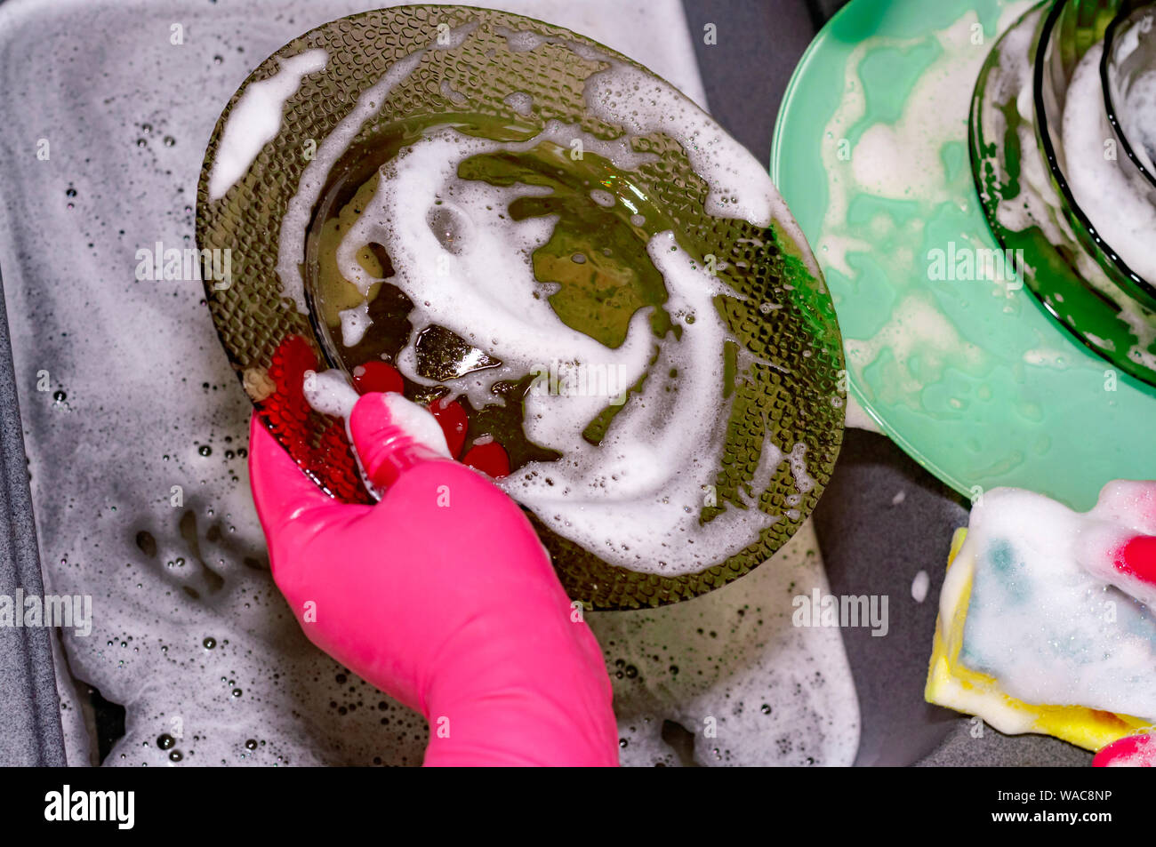 The process of washing plates in the sink, hands and plates closeup ...