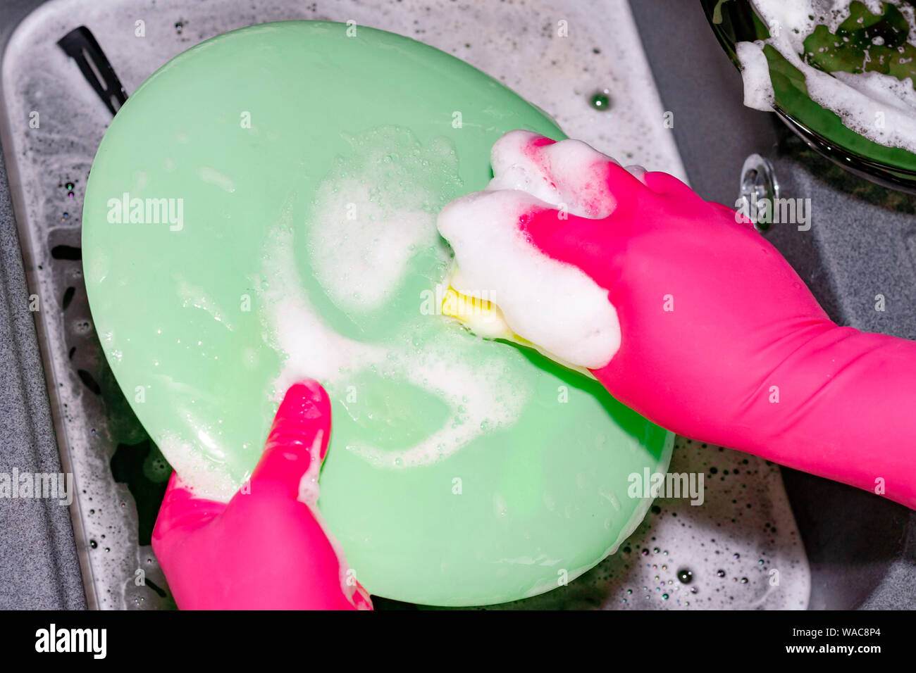 The process of washing plates in the sink, hands and plates closeup ...