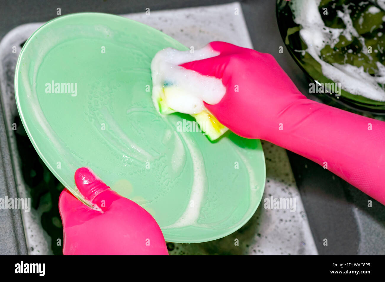 The process of washing plates in the sink, hands and plates closeup ...
