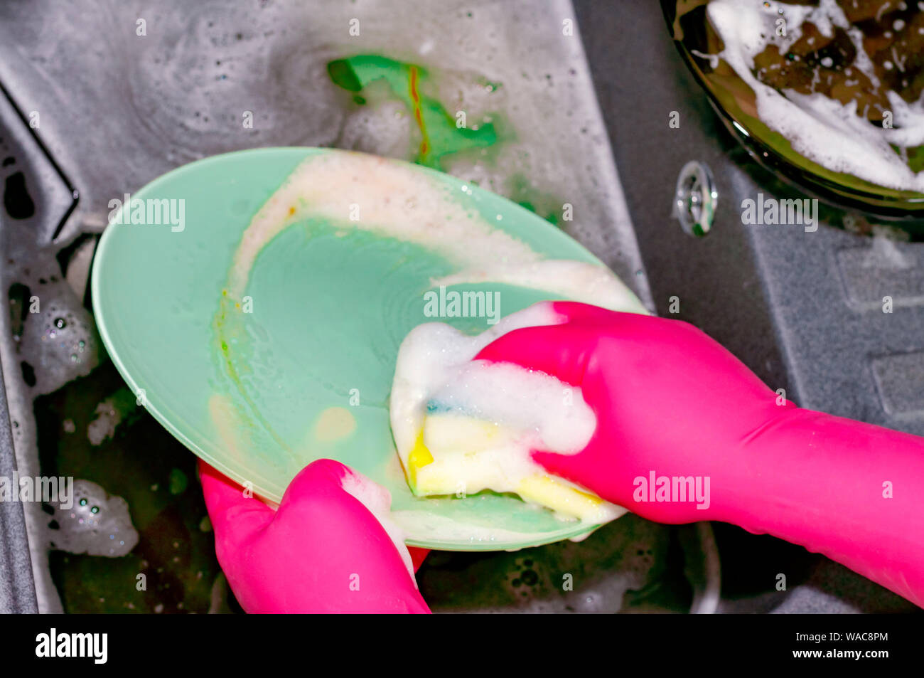 The process of washing plates in the sink, hands and plates closeup ...