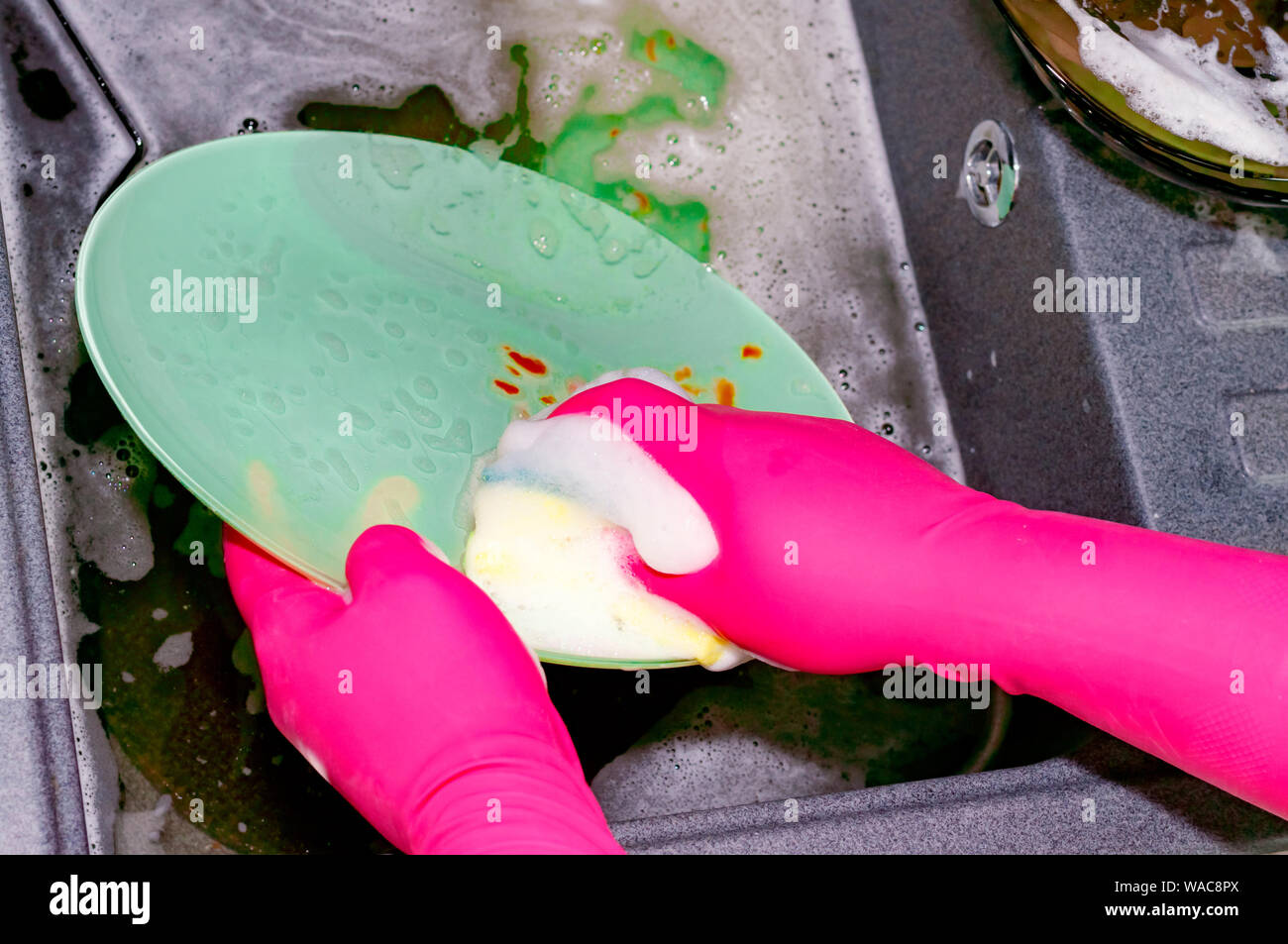 The process of washing plates in the sink, hands and plates closeup ...