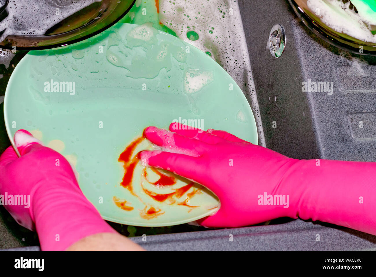 The process of washing plates in the sink, hands and plates closeup ...