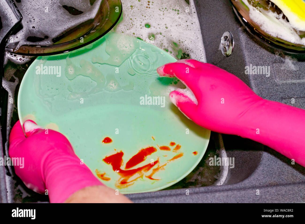 The process of washing plates in the sink, hands and plates closeup ...