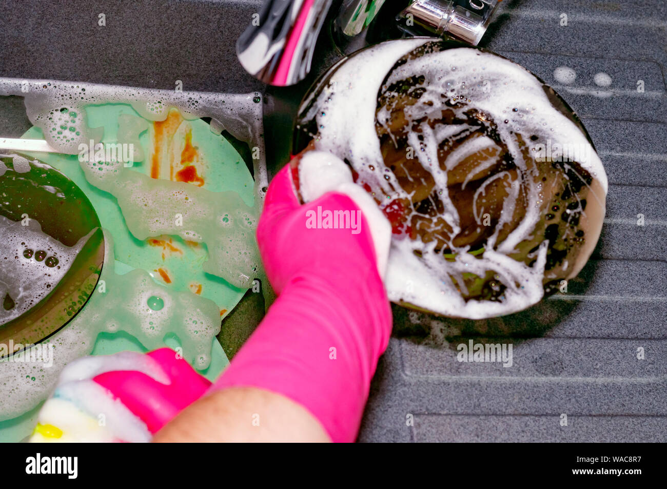 The process of washing plates in the sink, hands and plates closeup ...