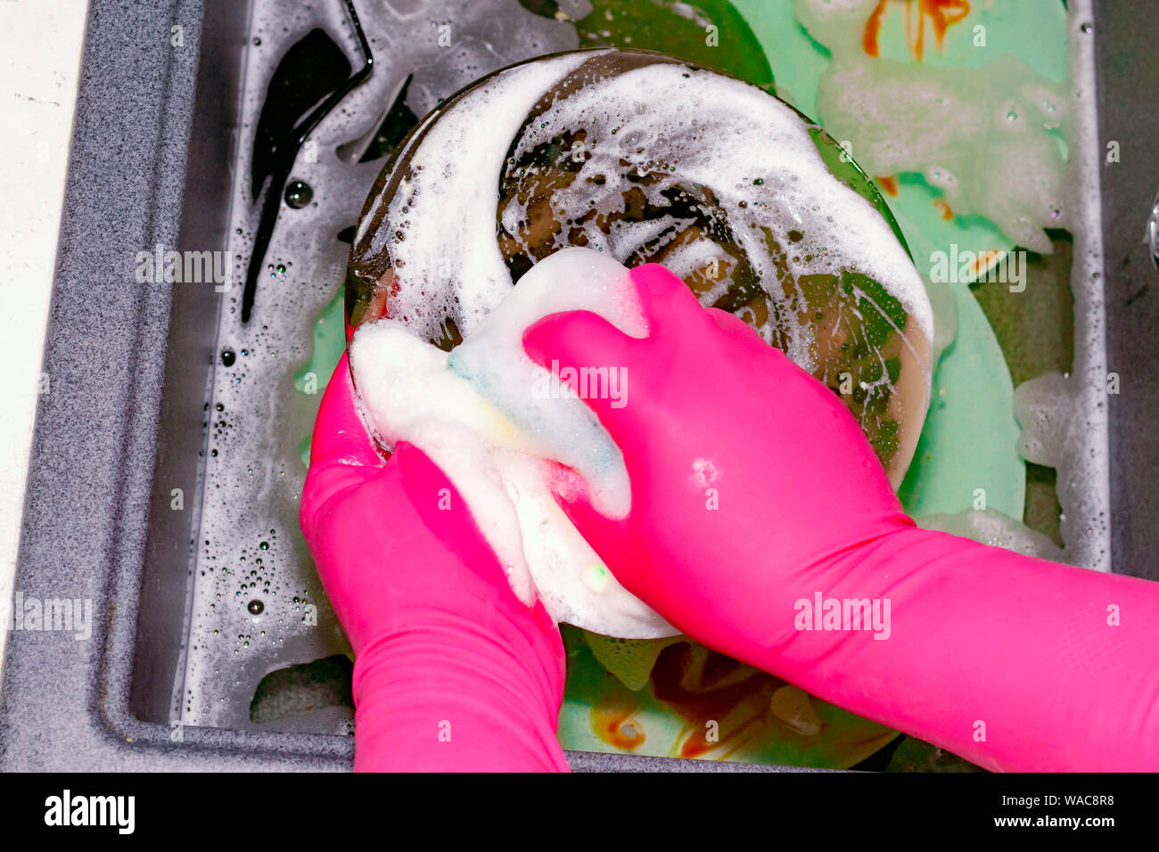 The process of washing plates in the sink, hands and plates closeup ...