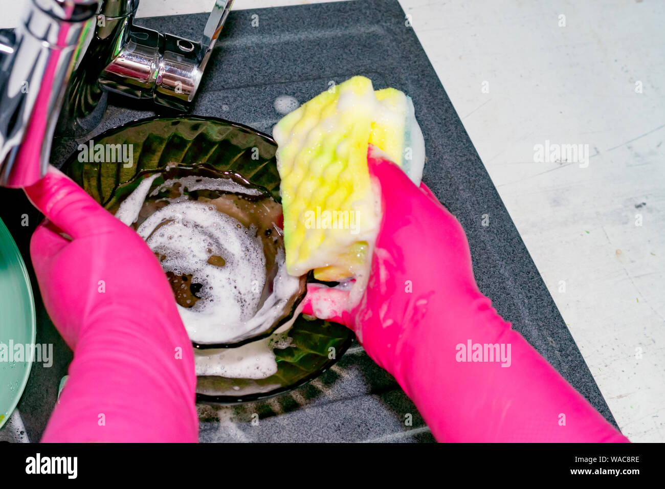 The process of washing plates in the sink, hands and plates closeup ...