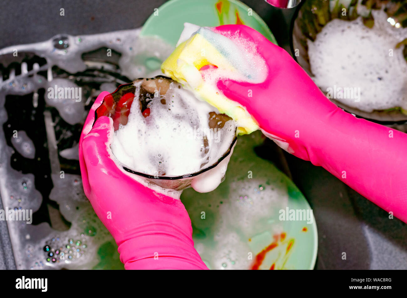The process of washing plates in the sink, hands and plates closeup ...