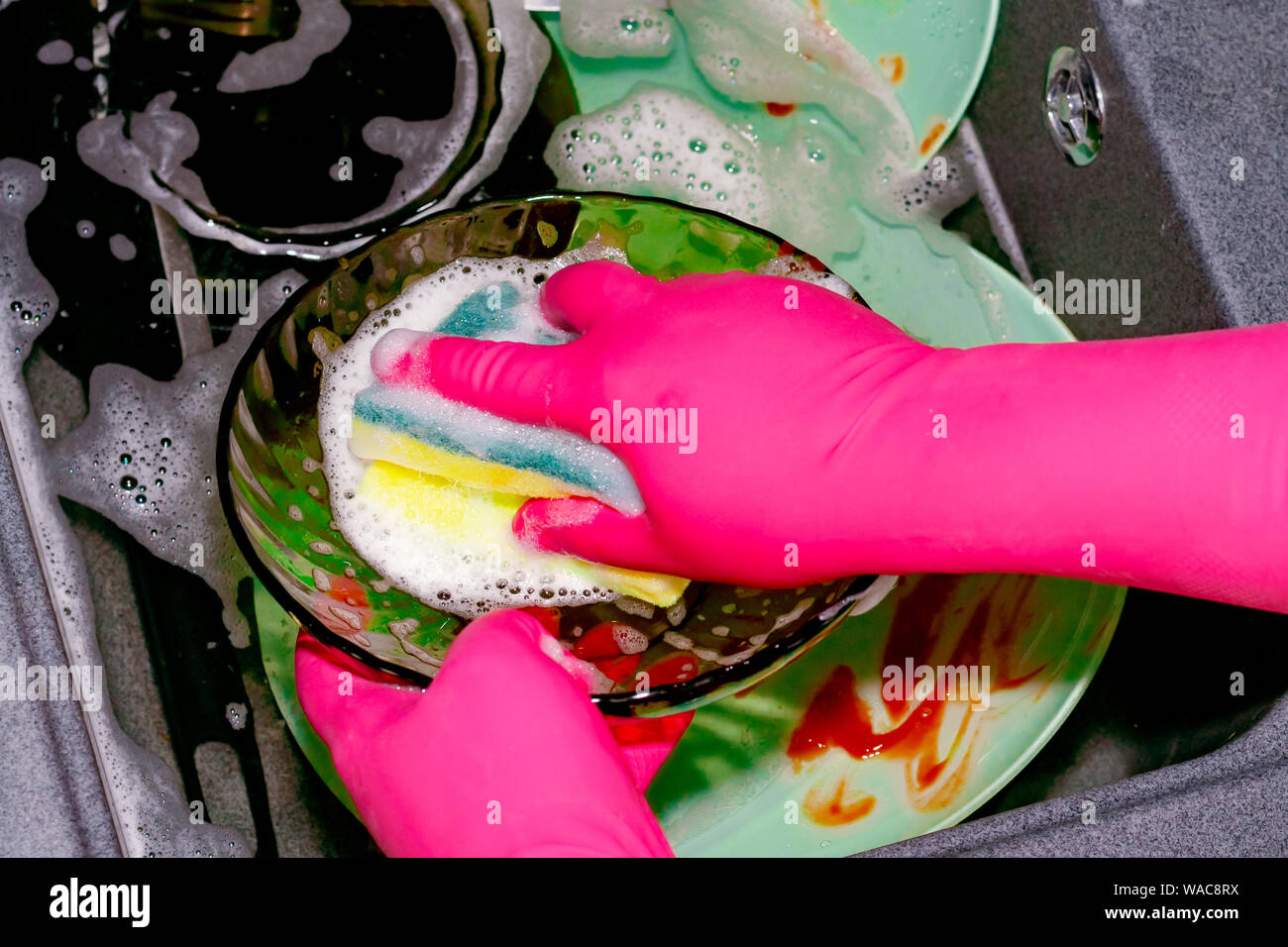 The process of washing plates in the sink, hands and plates closeup ...