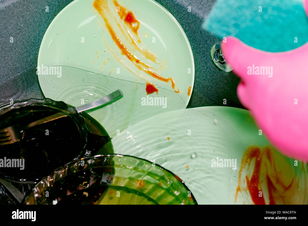 The process of washing plates in the sink, hands and plates closeup ...
