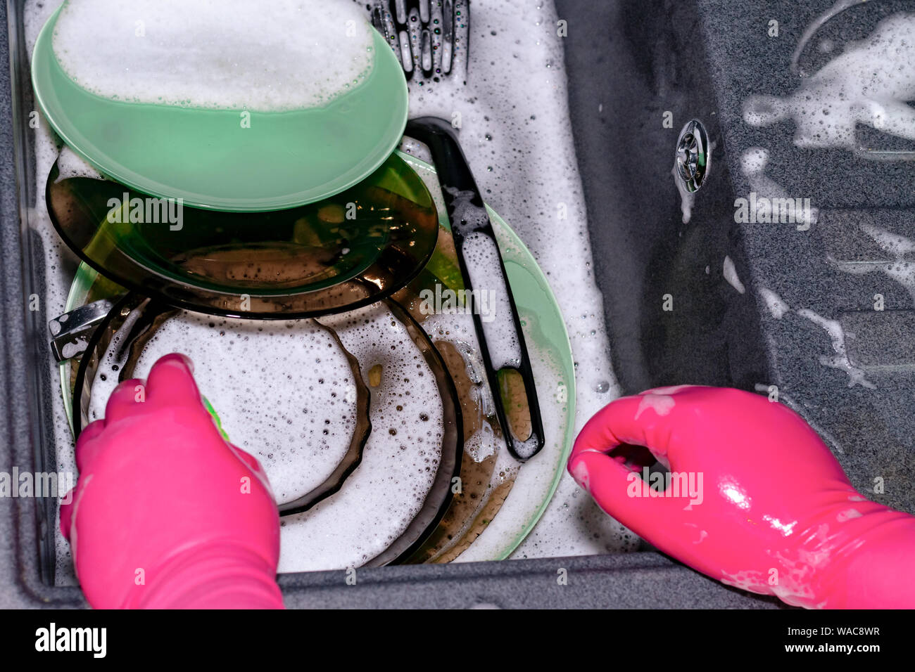 The process of washing plates in the sink, hands and plates closeup ...