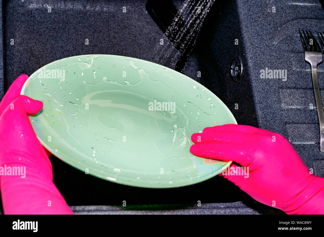 The process of washing plates in the sink, hands and plates closeup ...