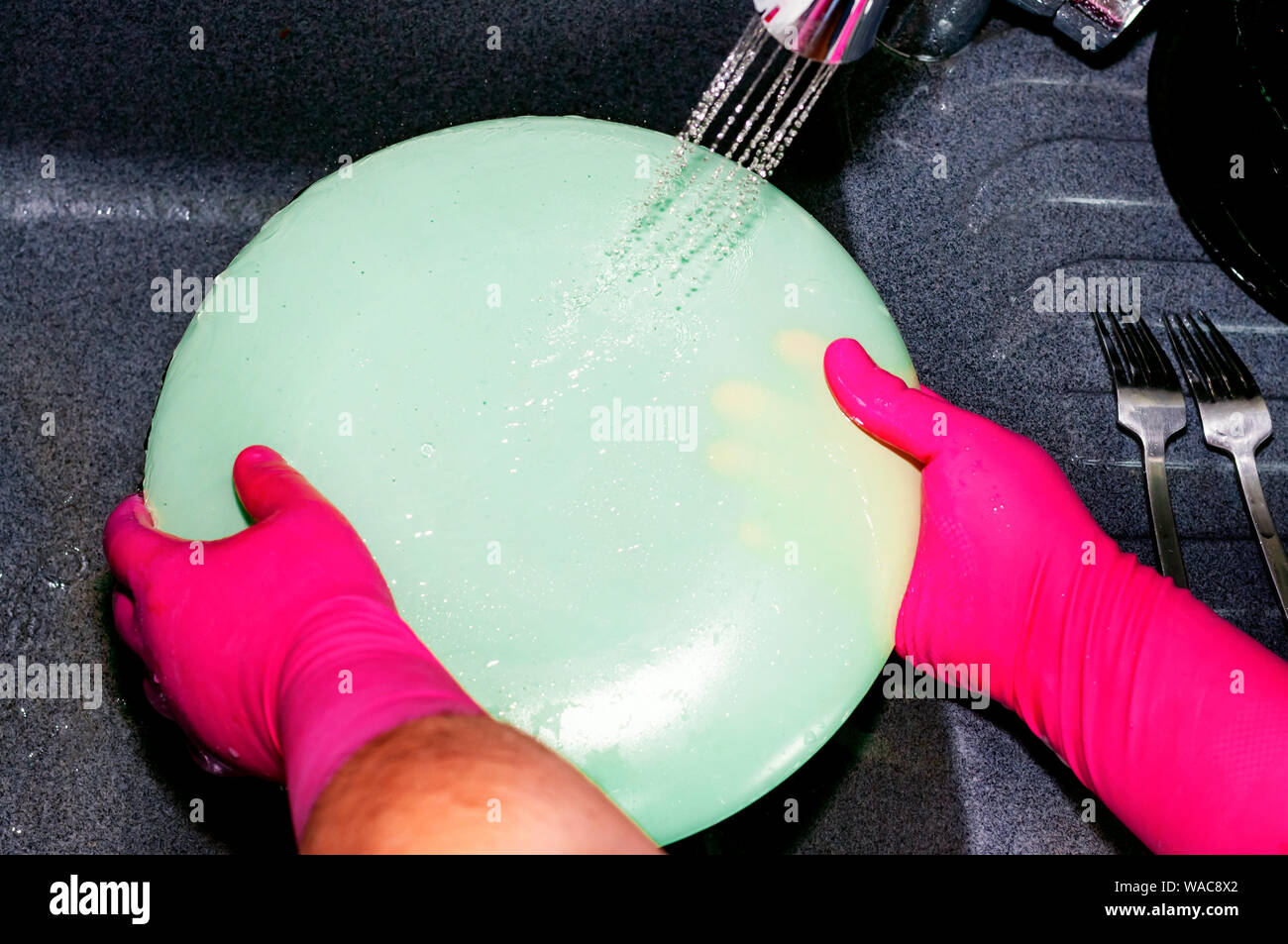 The process of washing plates in the sink, hands and plates closeup ...
