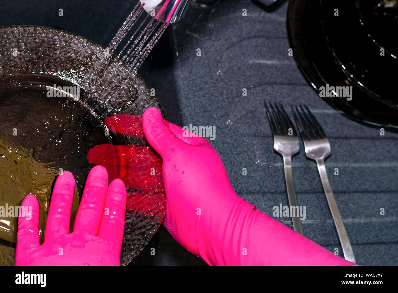 The process of washing plates in the sink, hands and plates closeup ...