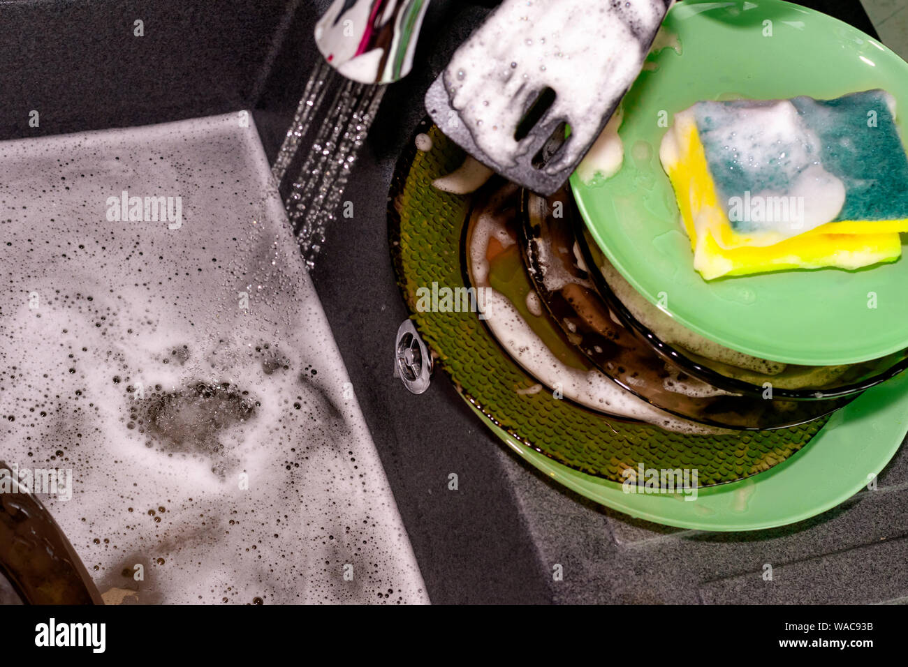 The process of washing plates in the sink, hands and plates closeup ...
