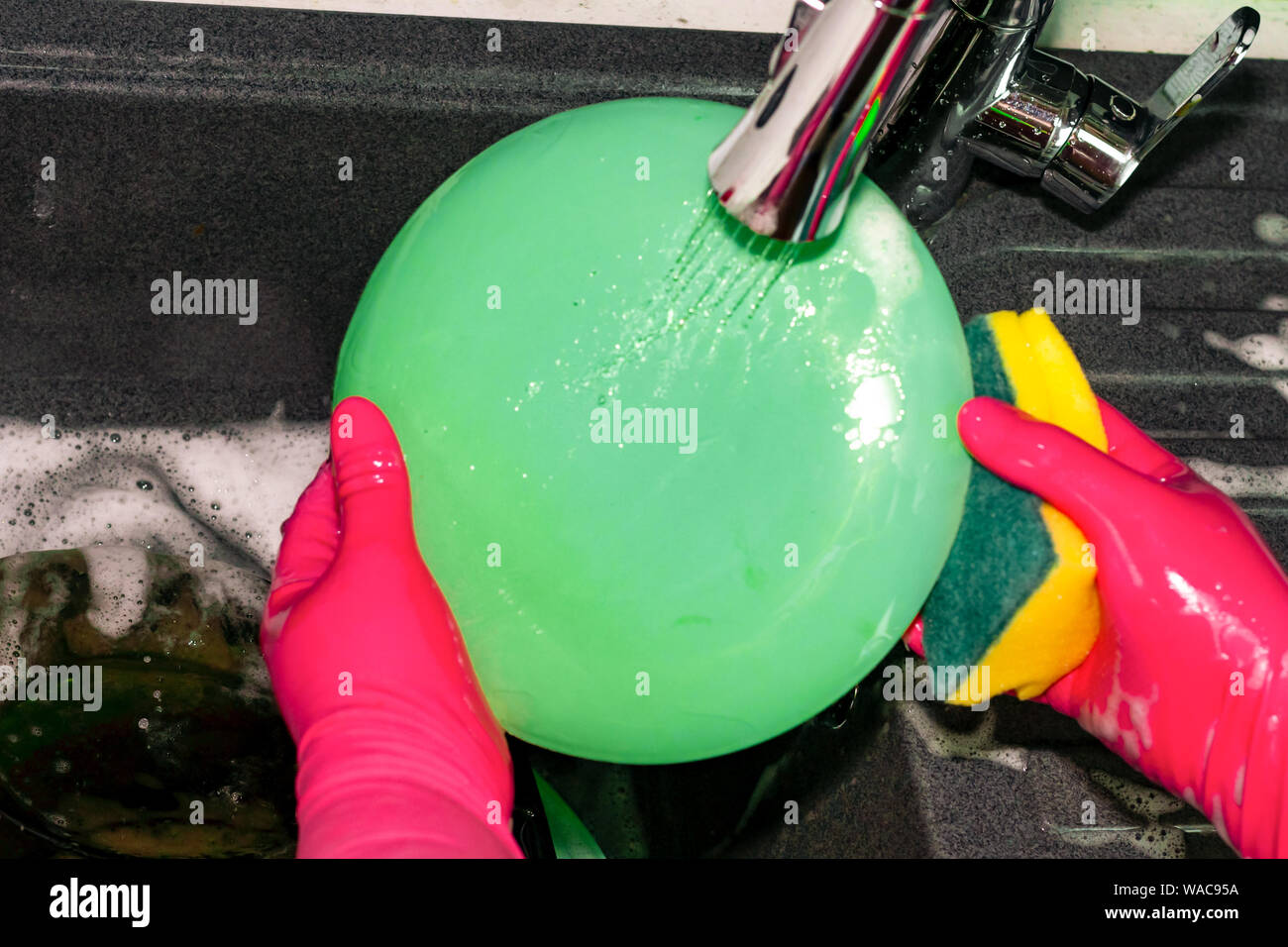 The process of washing plates in the sink, hands and plates closeup ...