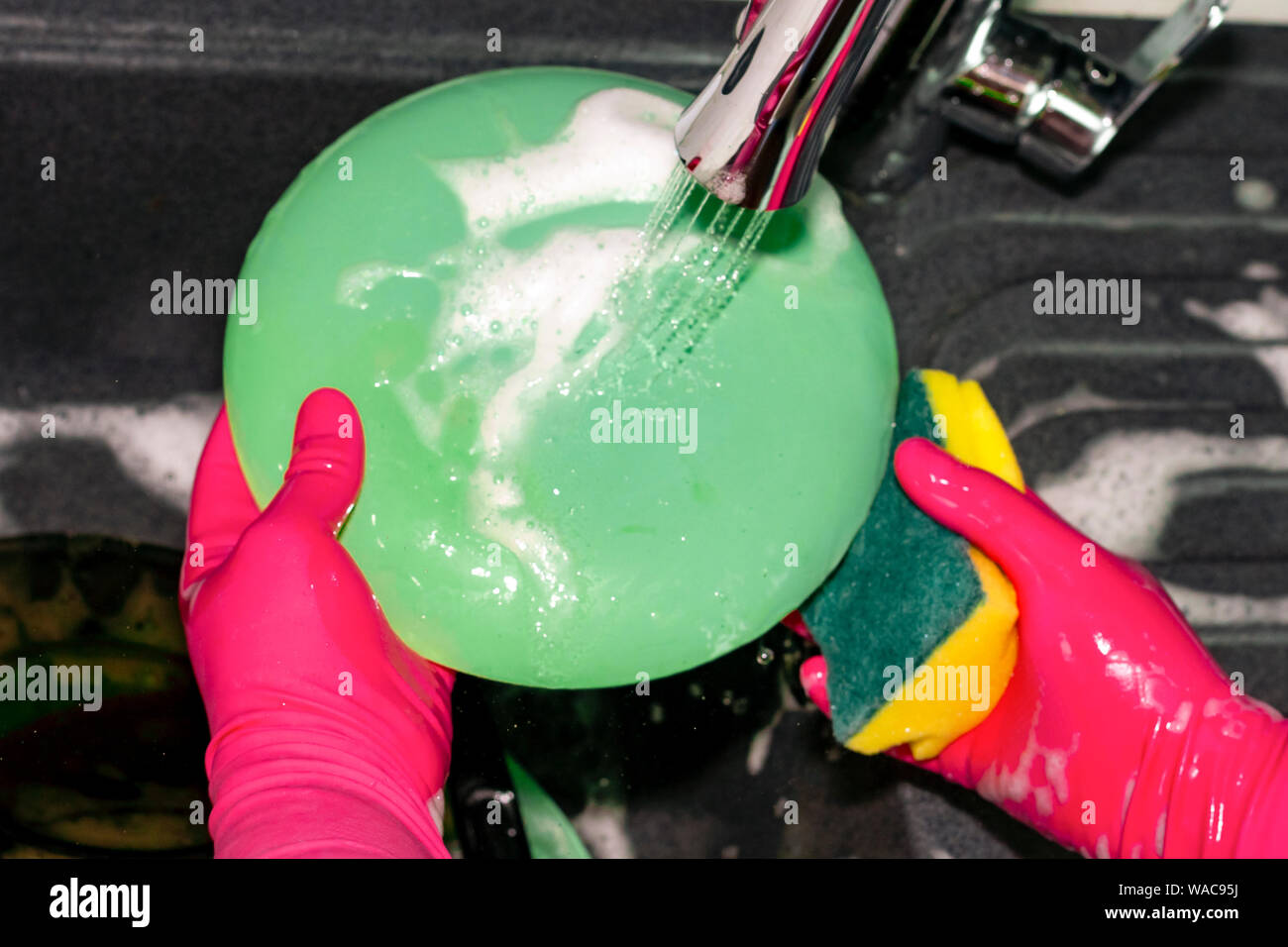 The process of washing plates in the sink, hands and plates closeup ...