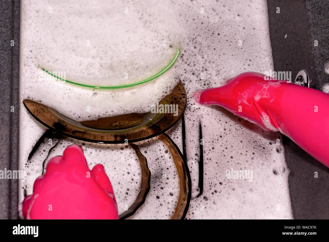 The process of washing plates in the sink, hands and plates closeup ...
