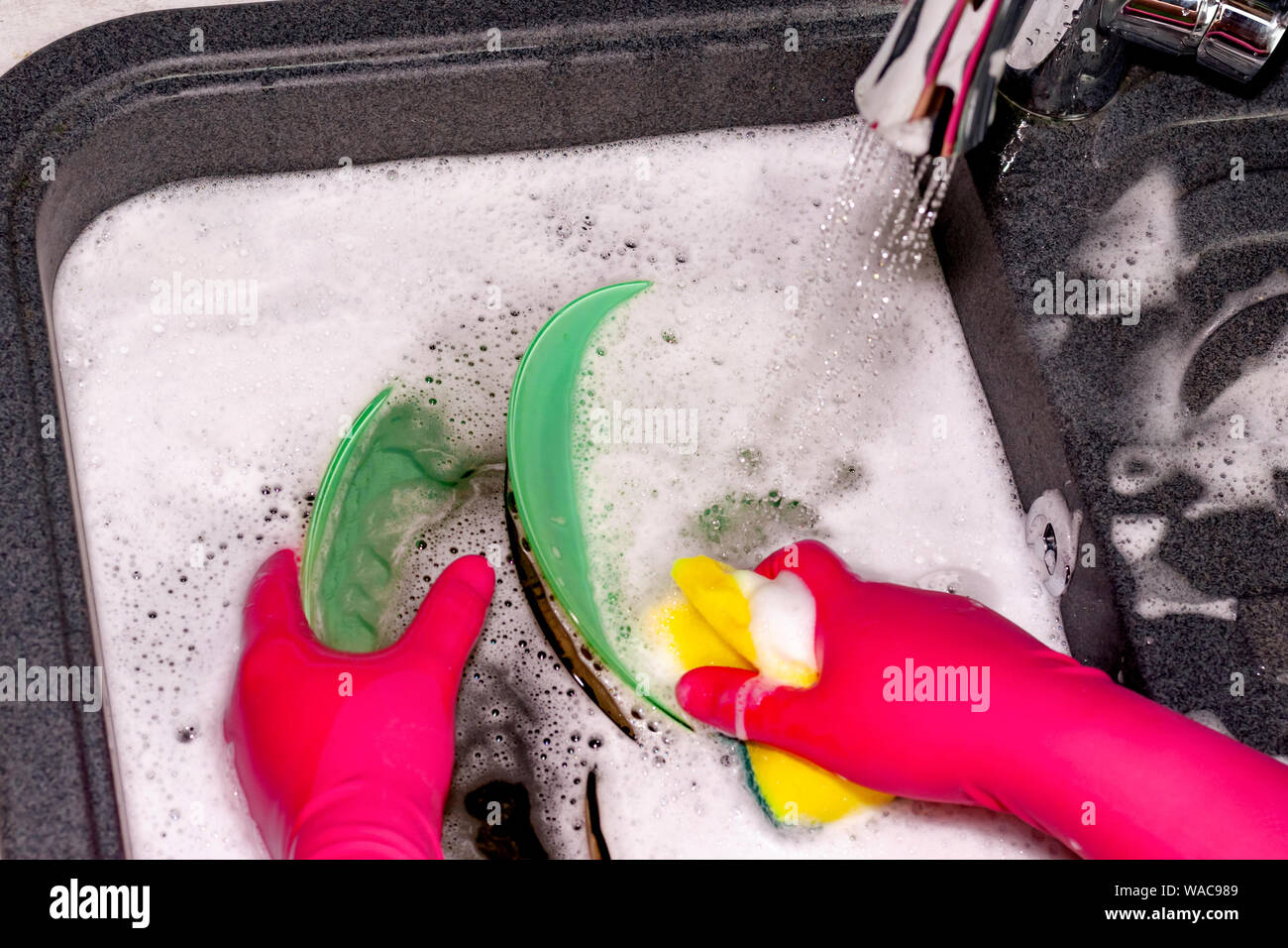 The process of washing plates in the sink, hands and plates closeup ...