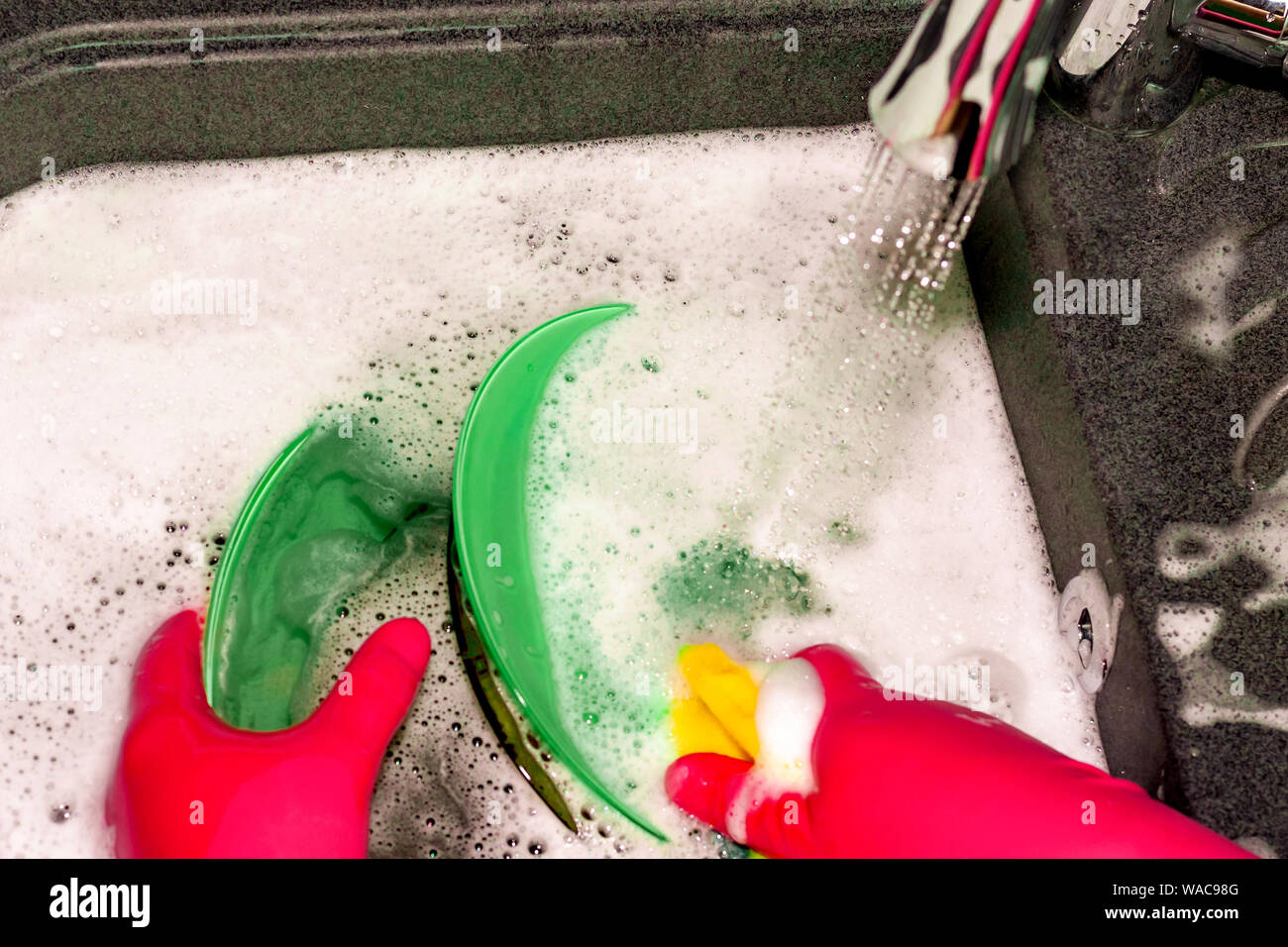 The process of washing plates in the sink, hands and plates closeup ...