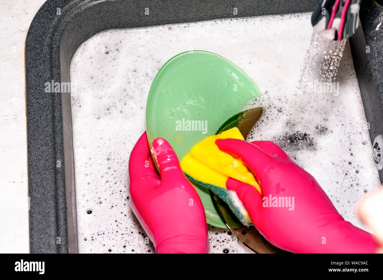 The process of washing plates in the sink, hands and plates closeup ...