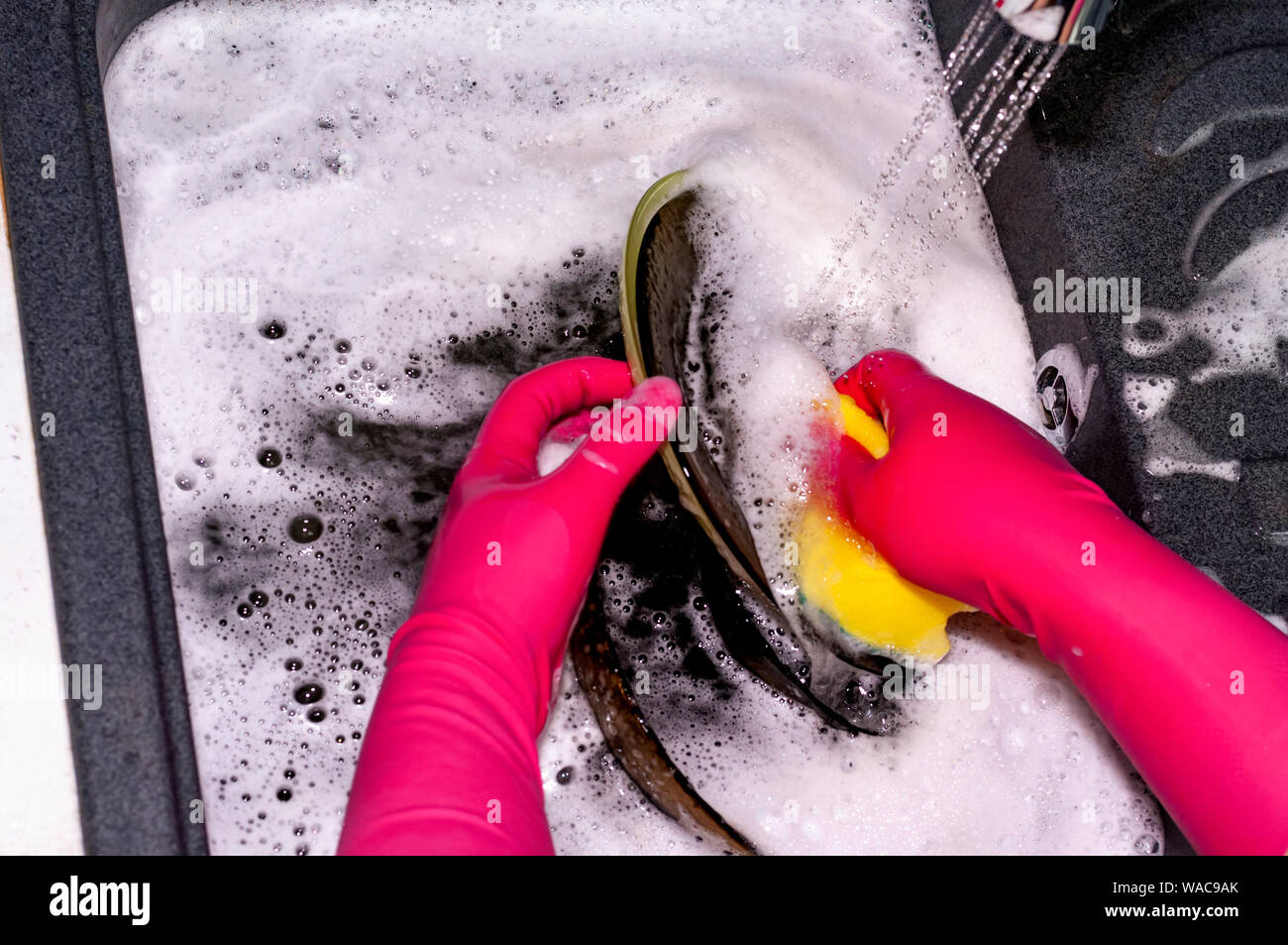 The process of washing plates in the sink, hands and plates closeup ...