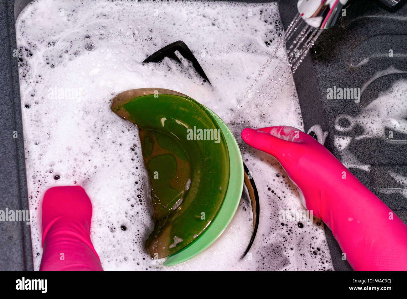 The process of washing plates in the sink, hands and plates closeup ...