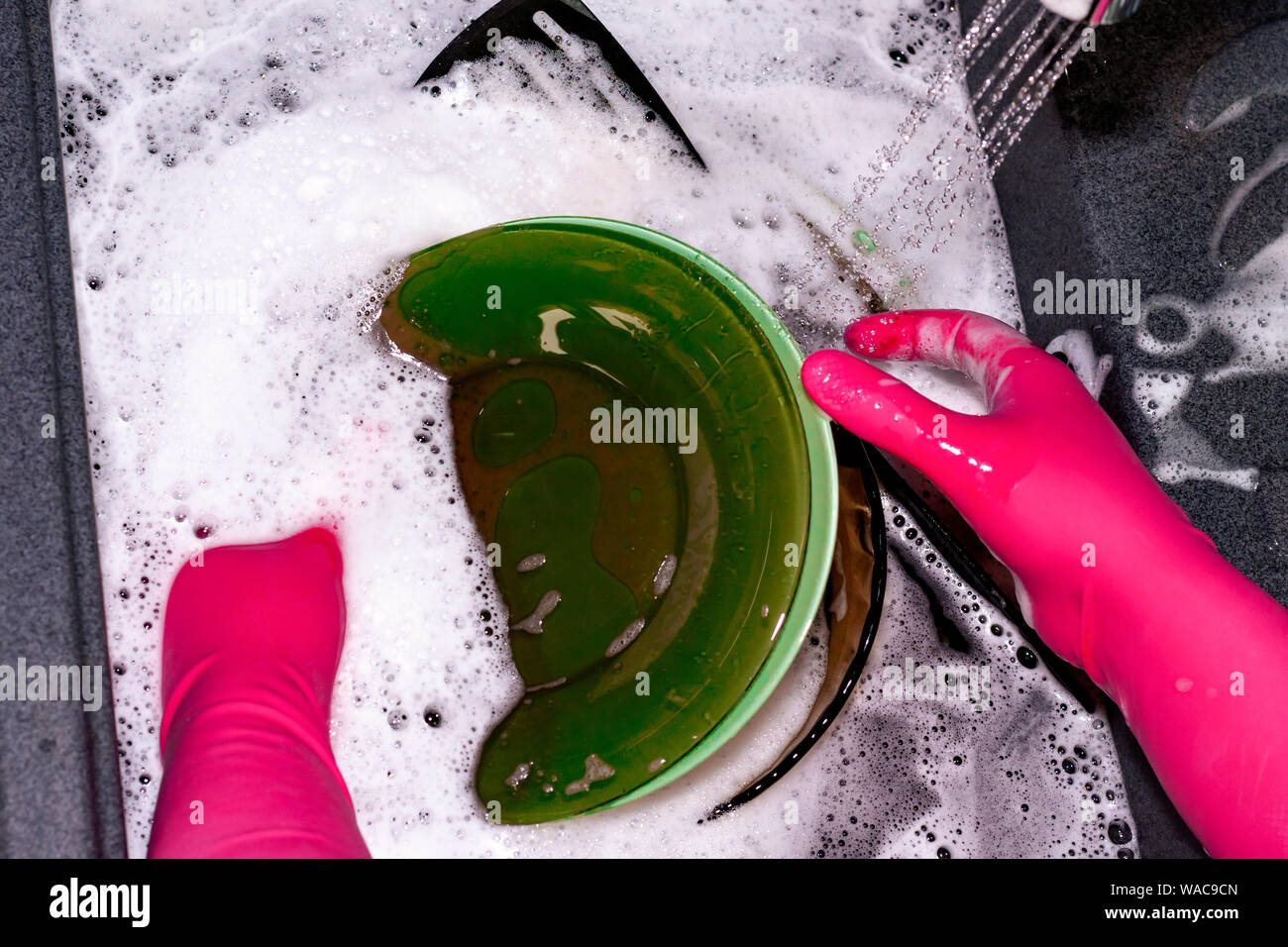The process of washing plates in the sink, hands and plates closeup ...