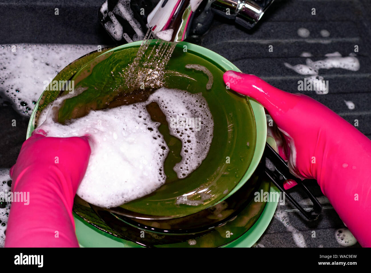The process of washing plates in the sink, hands and plates closeup ...
