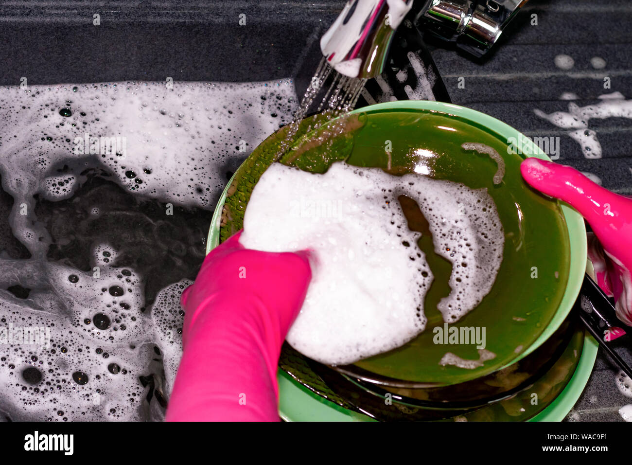 The process of washing plates in the sink, hands and plates closeup ...
