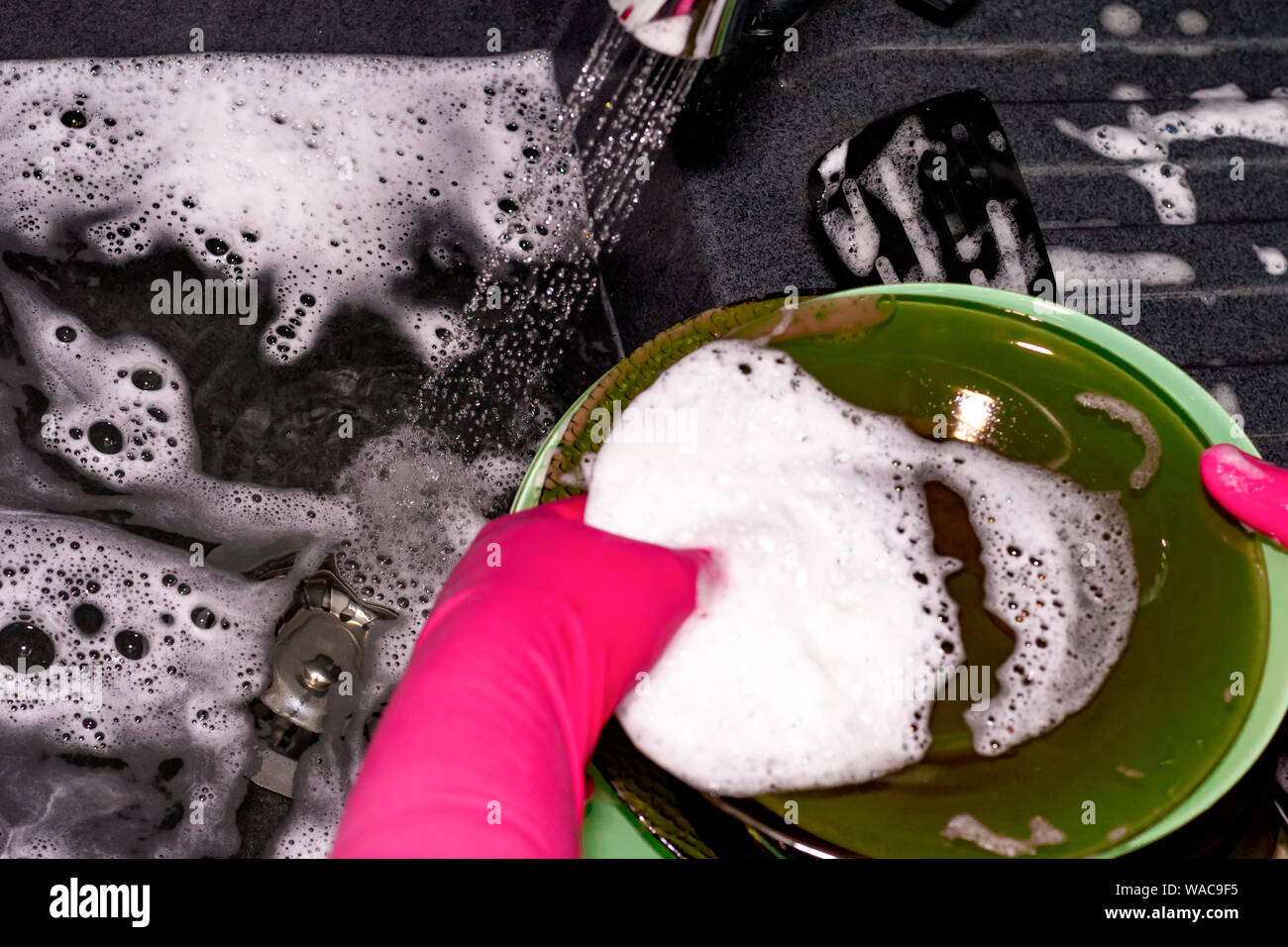 The process of washing plates in the sink, hands and plates closeup ...