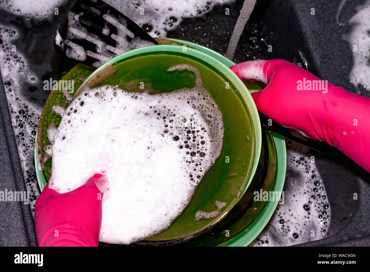 The process of washing plates in the sink, hands and plates closeup ...