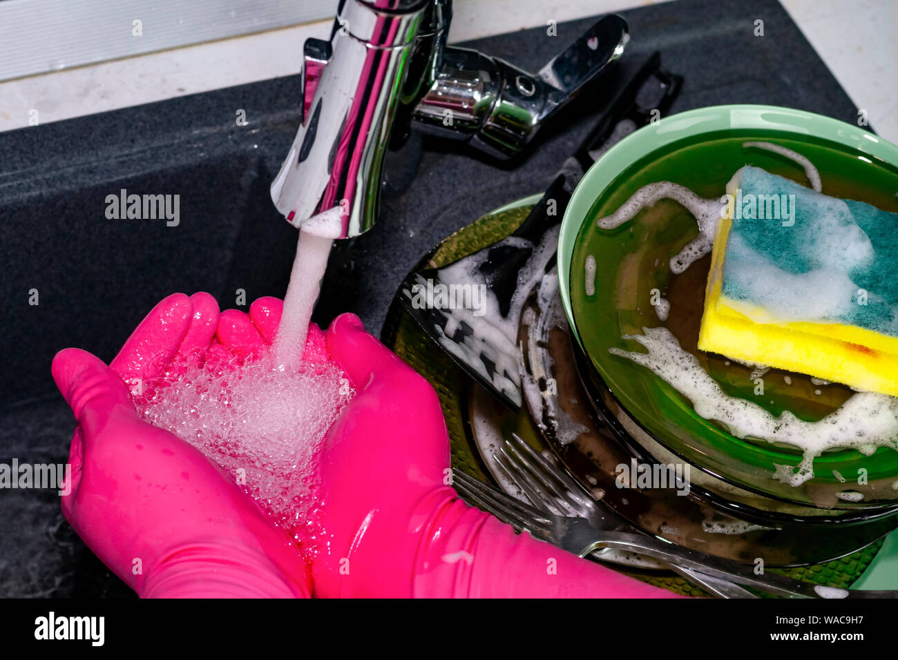 The process of washing plates in the sink, hands and plates closeup ...
