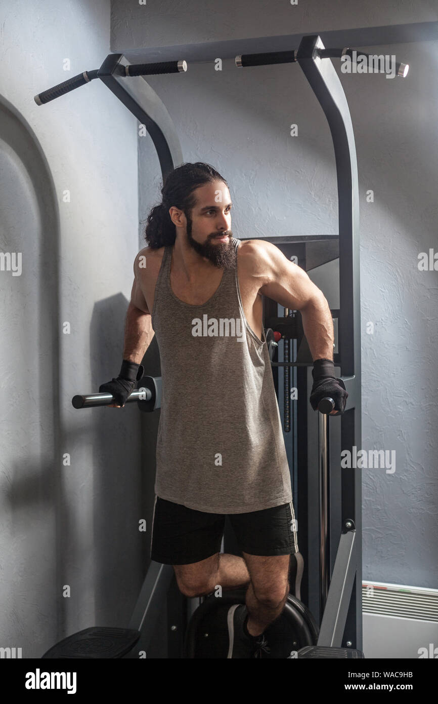 Full length portrait of confident young adult strong man with long ...