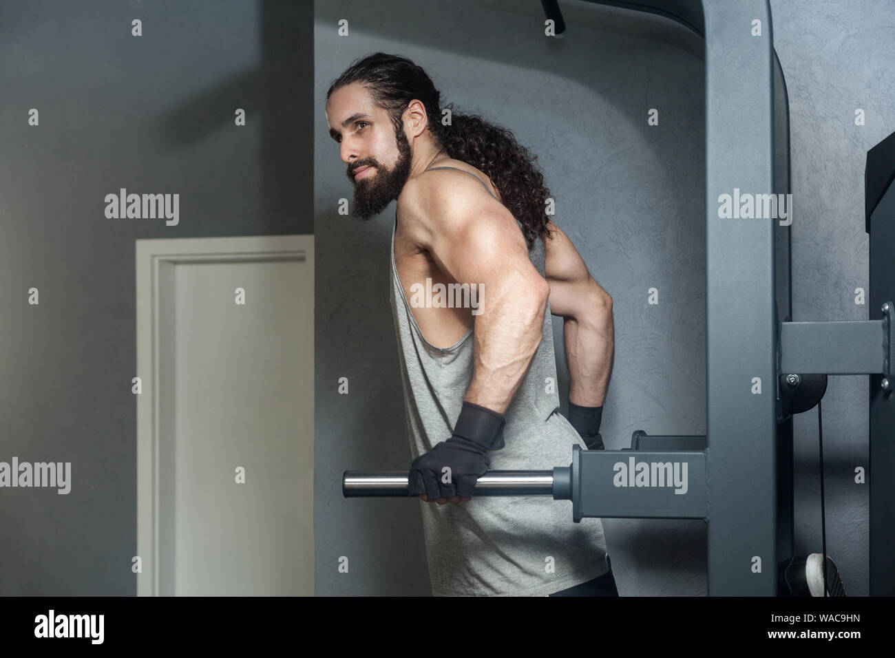 Portrait of powerful confident young adult strong man with long curly ...
