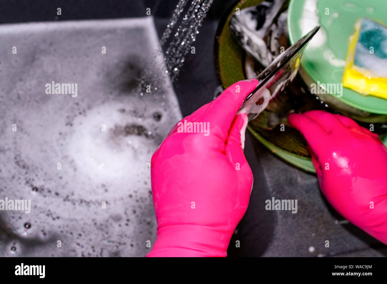 The process of washing plates in the sink, hands and plates closeup ...