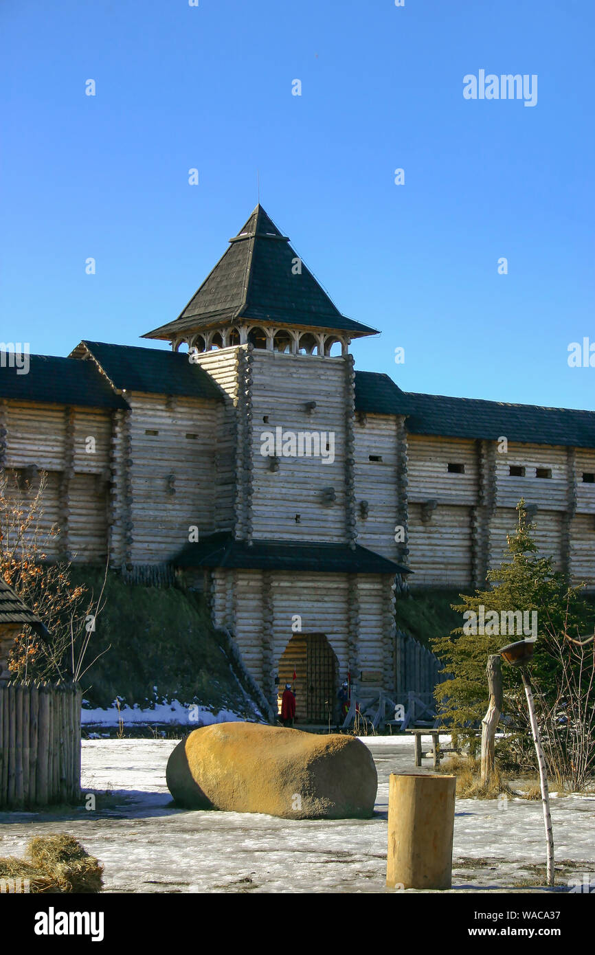 A powerful ancient wooden fortress with a central tower and a gate ...