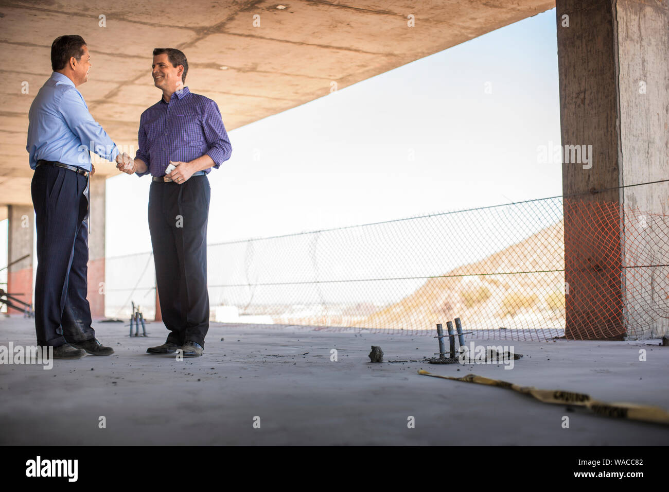 Two executives discuss plans on construction site Stock Photo - Alamy
