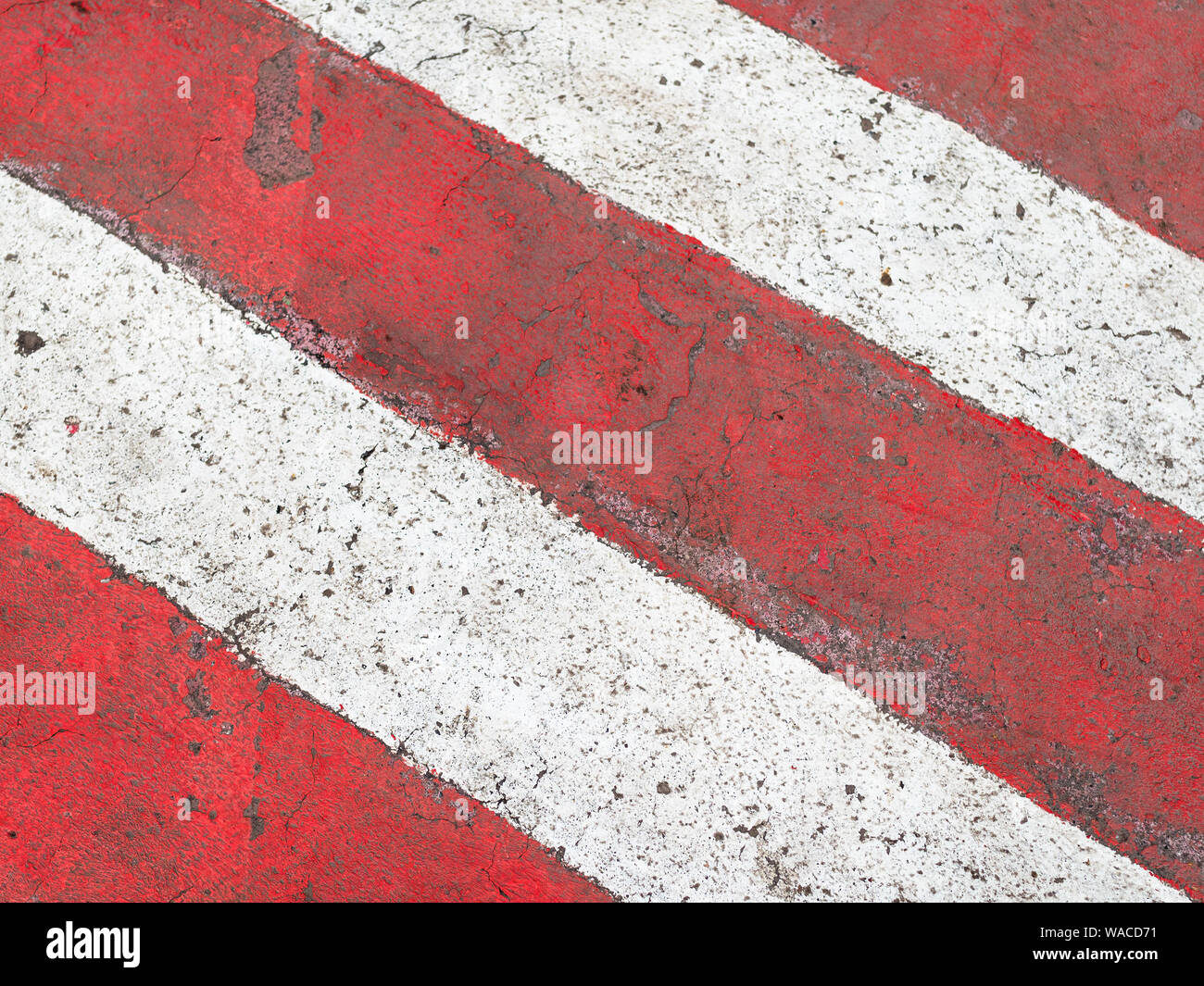 urban background - red and white stripes on asphalt road in parking ...