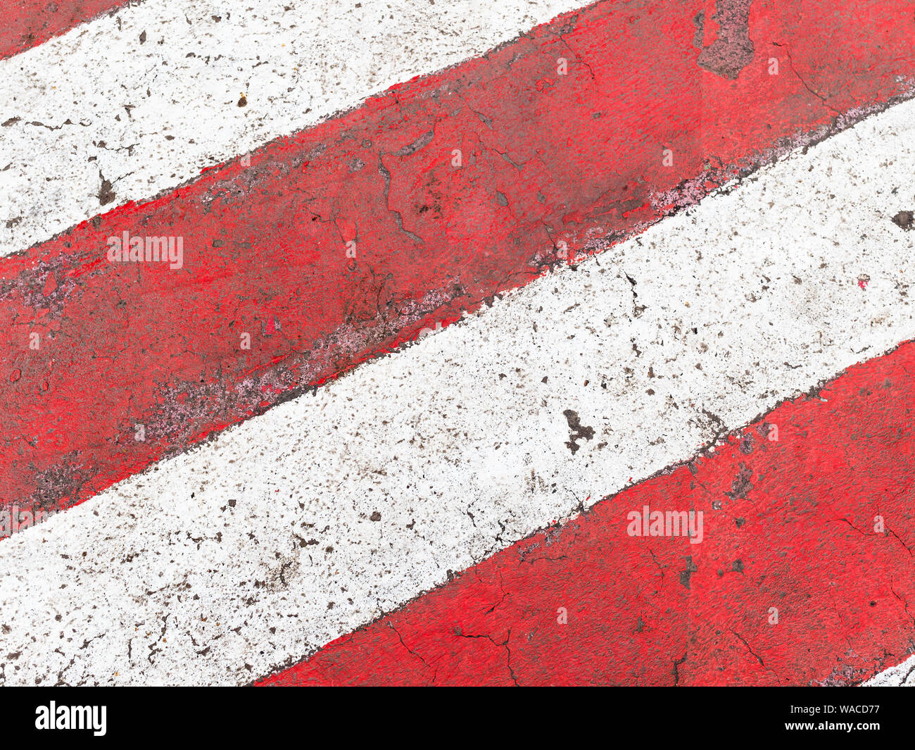 urban background - painted red and white stripes on asphalt road in ...