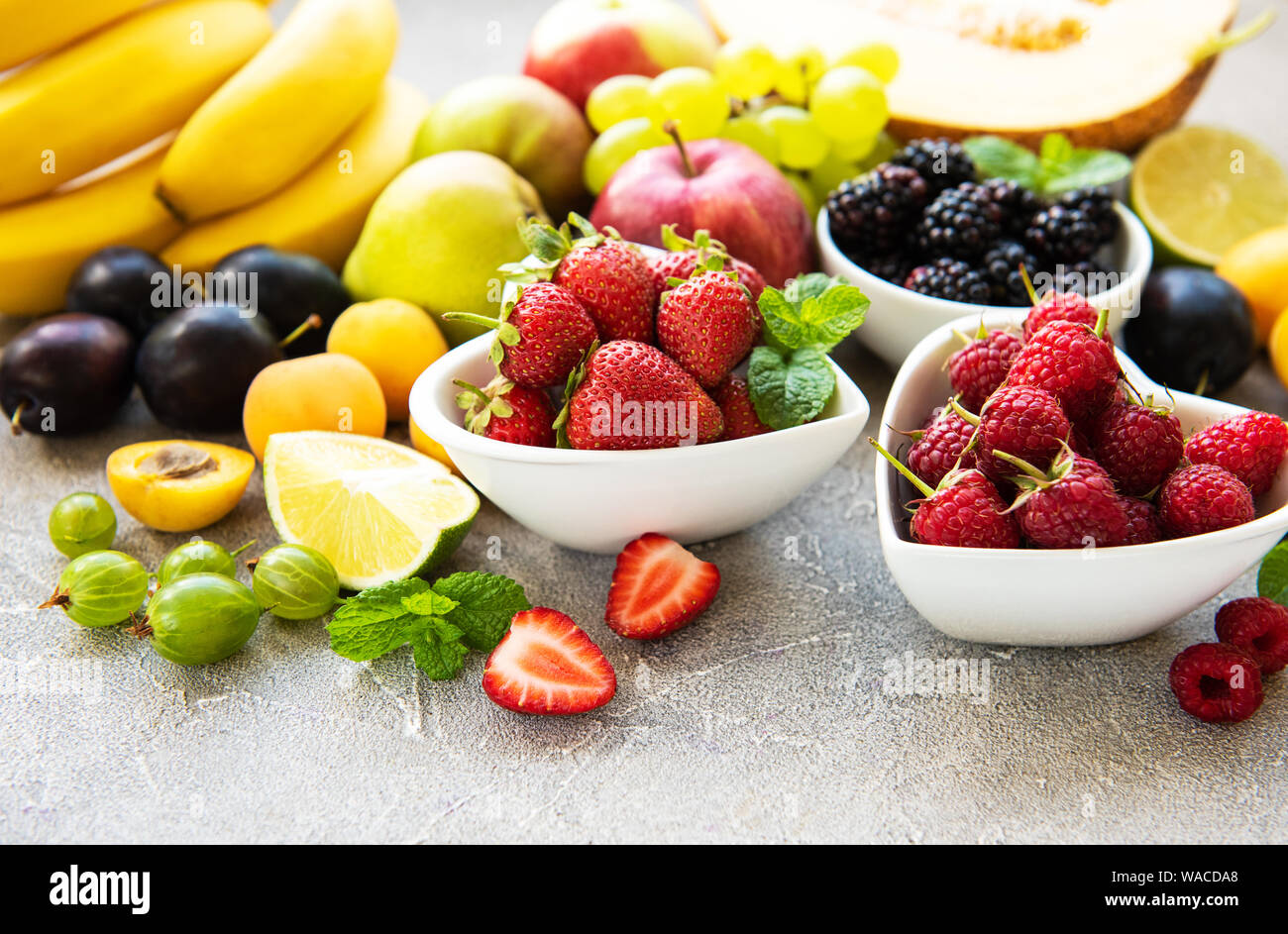 Fresh summer fruits and berries on a concrete background Stock Photo ...