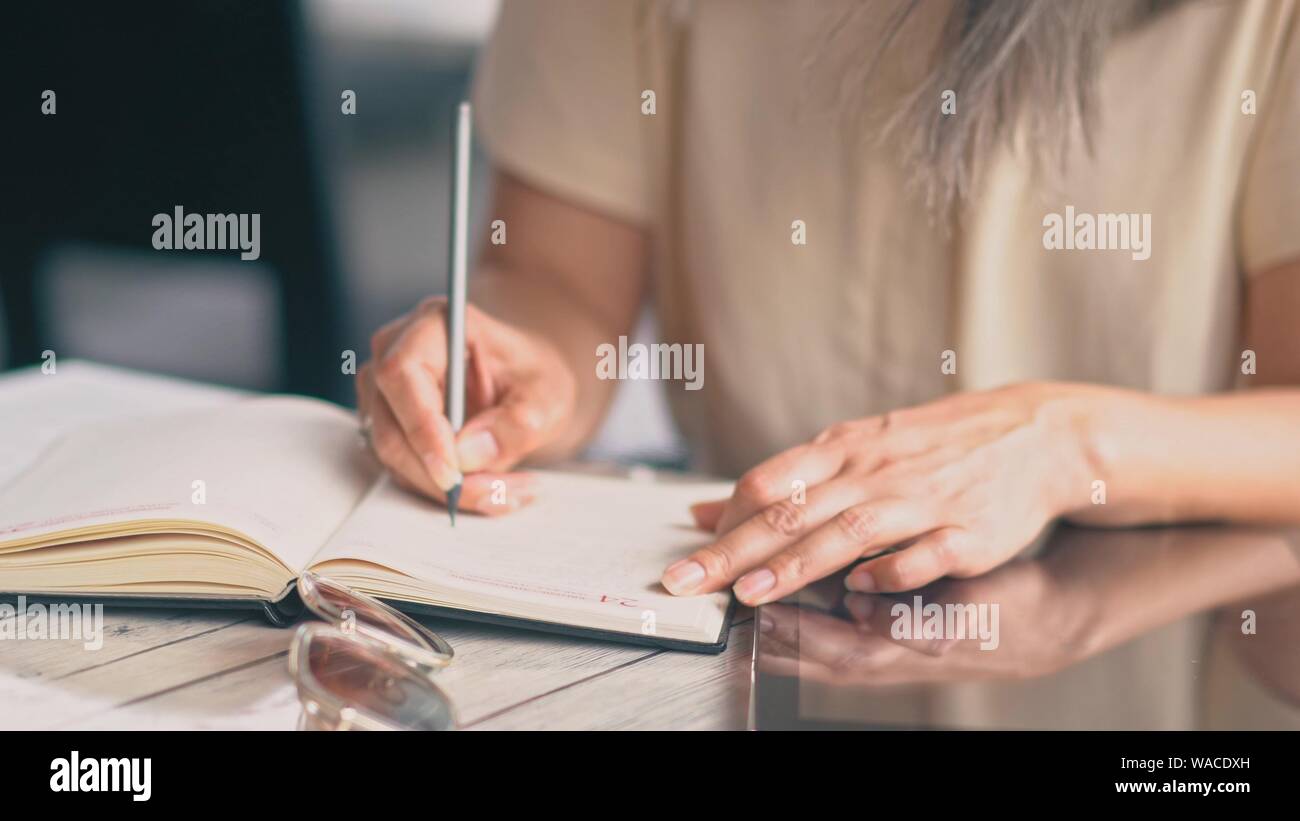 The Woman Is Writing In The Notebook And Drinking Stock Photo - Alamy