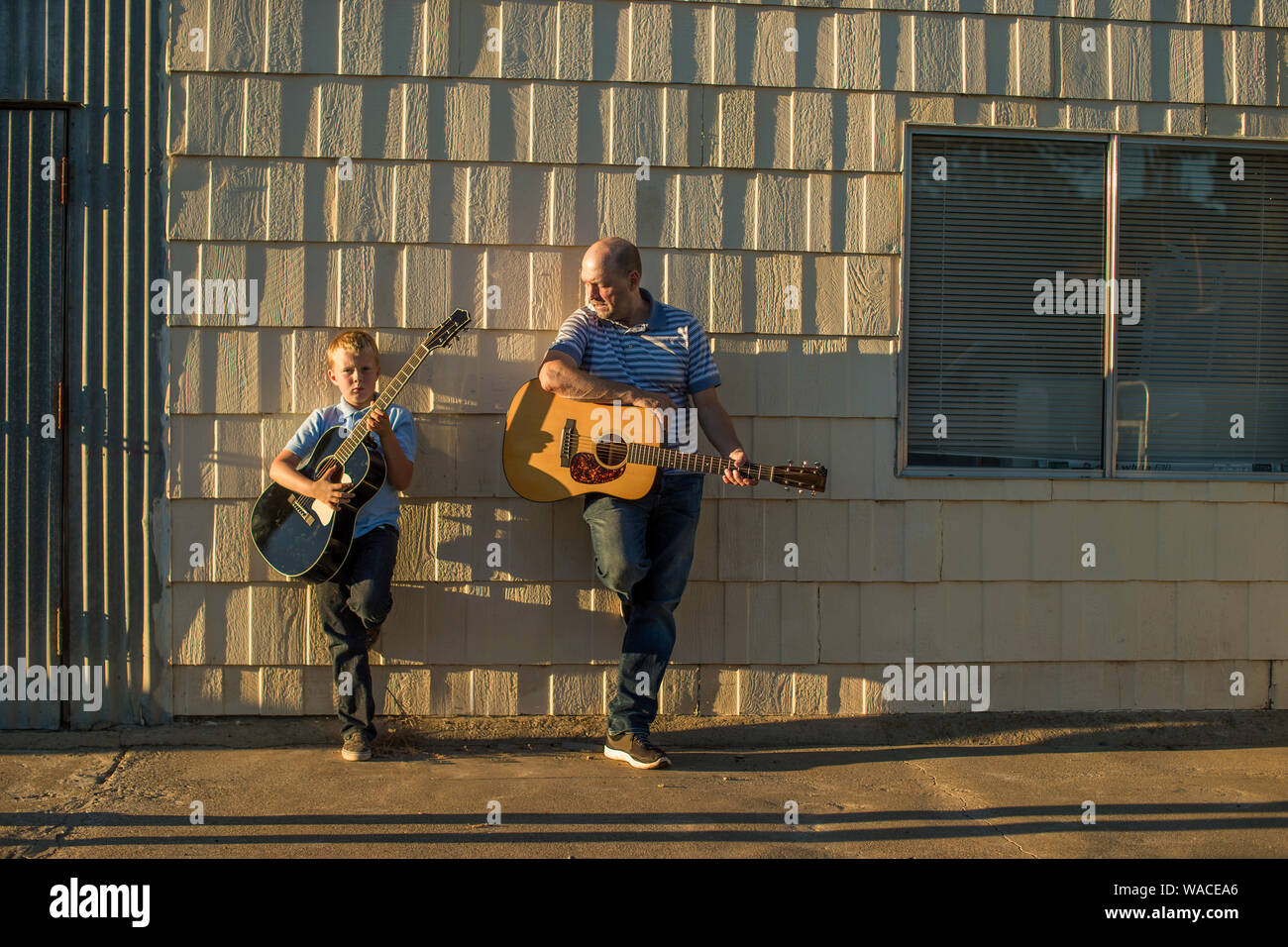 Father playing guitar with his son Stock Photo - Alamy