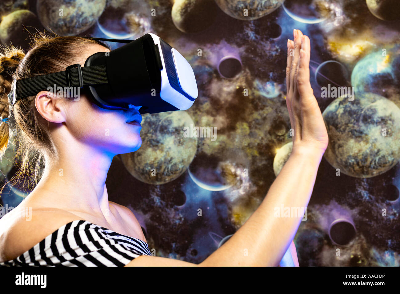 A woman is looking through virtual reality at space. Space background ...
